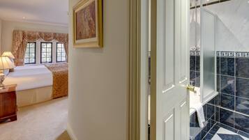 Quarto de hotel com cama, mesa de cabeceira, abajur e um quadro na parede.