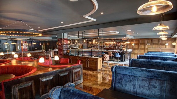 Uma área de bar moderna com lugares sentados e balcão.