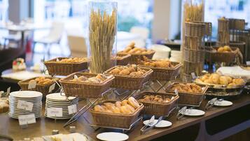 Uma mesa de buffet com diversos alimentos e cestas.