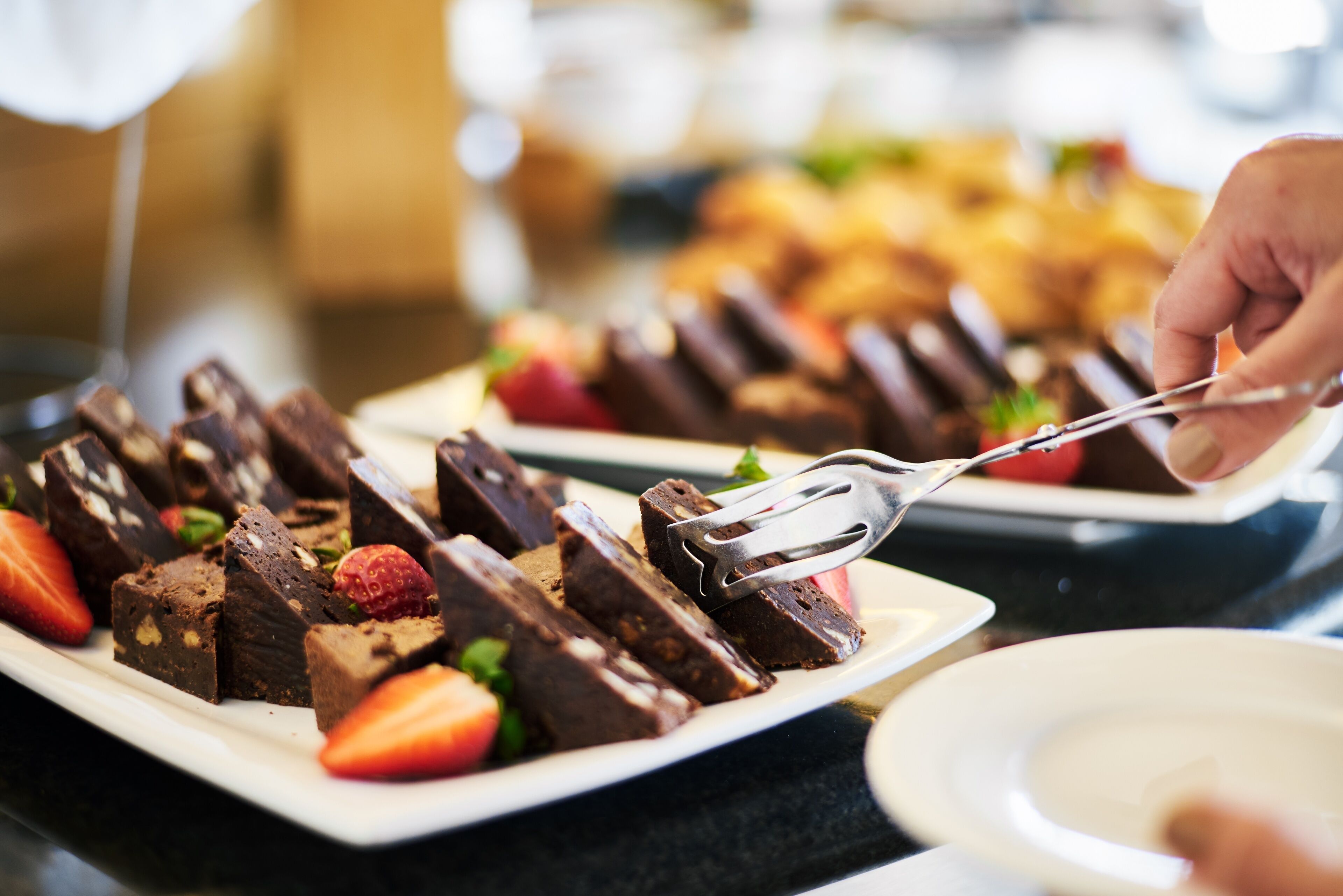 Um buffet com sobremesas de chocolate e morangos.