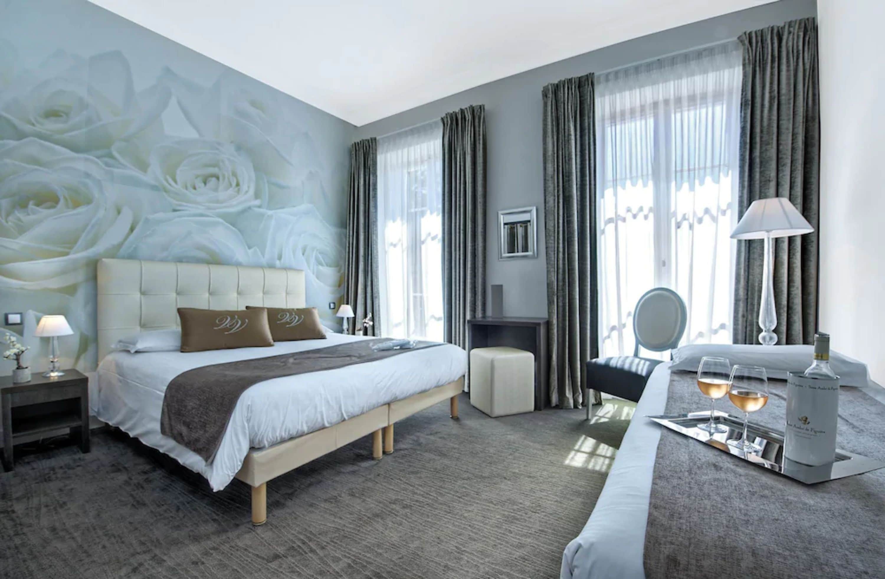 Quarto de hotel moderno com uma cama grande, área de estar com uma mesa e lareira.