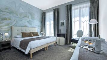 Quarto de hotel moderno com uma cama grande, área de estar com uma mesa e lareira.