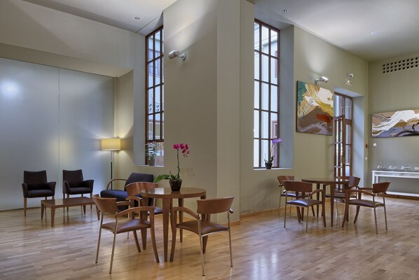 Um quarto espaçoso com piso de madeira, uma mesa de jantar redonda e várias cadeiras.