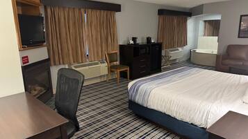 Quarto de hotel com cama, escrivaninha, cadeira, televisão, aquecedor e banheira.