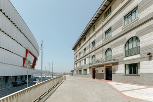 Um edifício moderno com fachada curva e um edifício tradicional com janelas arqueadas.