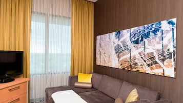 Suíte, 1 cama King e sofá-cama | Área de estar | TV de plasma
