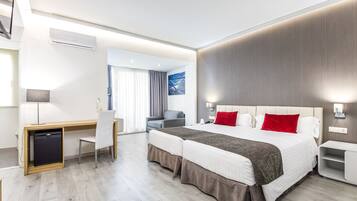Quarto de hotel moderno com uma cama grande, uma escrivaninha e uma cadeira.