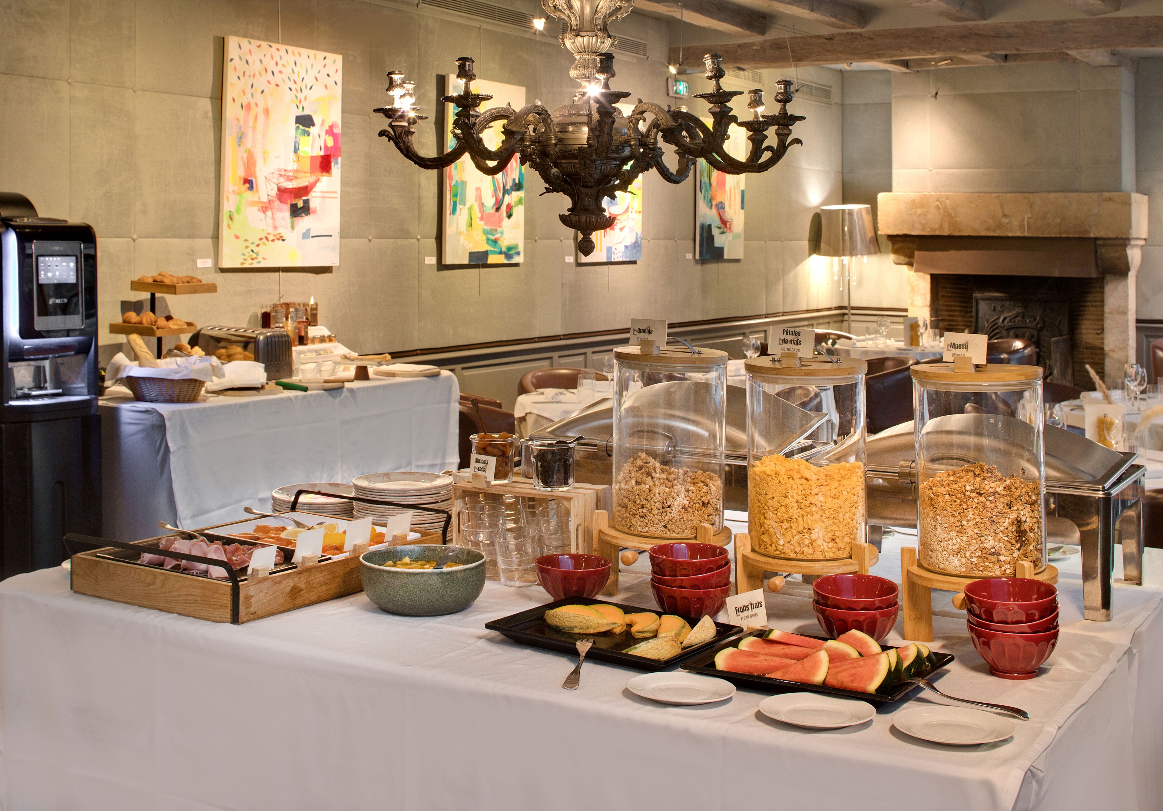 Disposição de buffet com diversos alimentos e uma máquina de café.