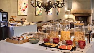 Disposição de buffet com diversos alimentos e uma máquina de café.
