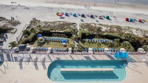 Um resort à beira-mar com piscina, espreguiçadeiras e guarda-sóis.