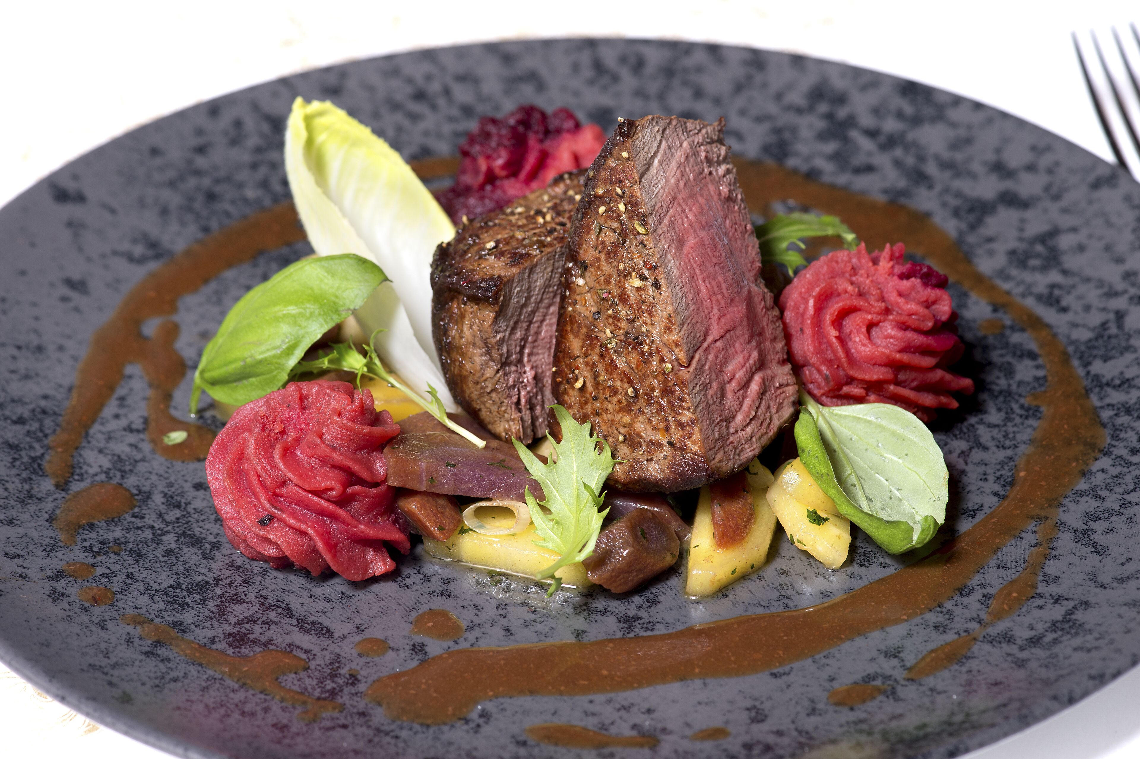 Prato de comida com bife, legumes e molho.