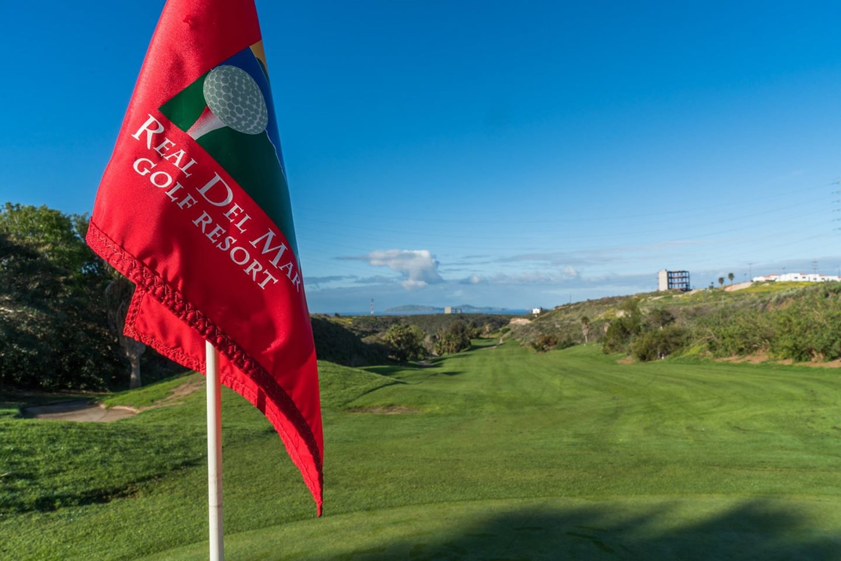 Uma bandeira de golfe no Real Del Mar Golf Resort, com vista clara para o campo de golfe.