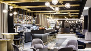 Uma área de bar moderna com balcão, assentos e piso estampado.