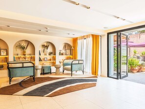 Um interior moderno com área de estar, um tapete grande e vista para o pátio externo.