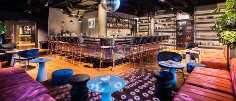 Uma área de bar com balcão, assentos e uma bola de discoteca.