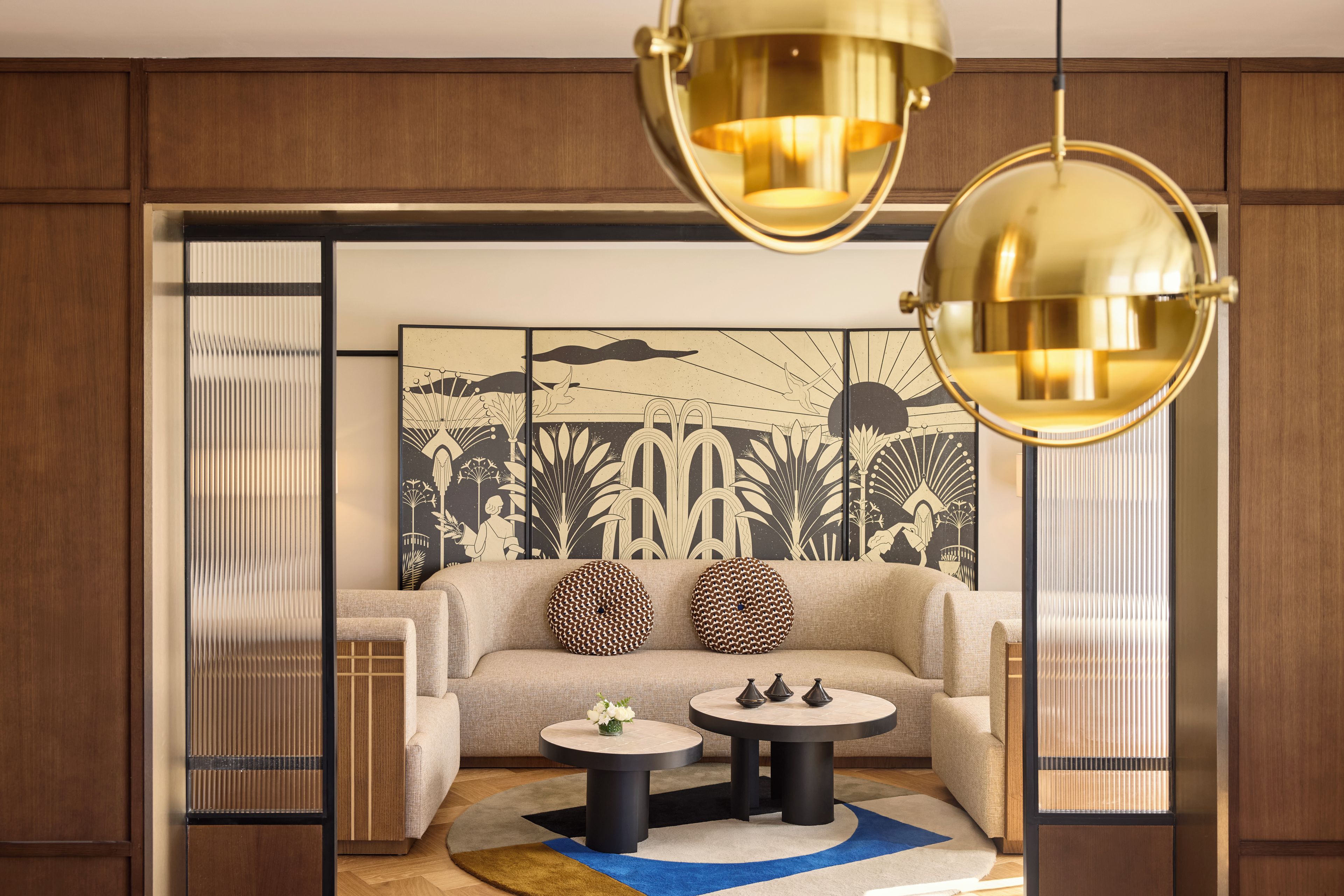 Uma sala de estar moderna com um sofá, duas mesas redondas e almofadas decorativas.