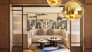 Uma sala de estar moderna com um sofá, duas mesas redondas e almofadas decorativas.