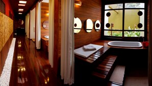 Um quarto de spa com paredes de madeira, um banco de madeira, uma pia e uma janela com vista para o verde.