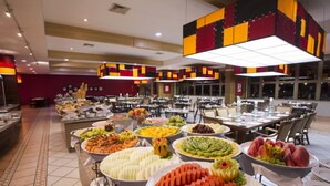 Um buffet com diversas opções de comida e uma área de estar com mesas e cadeiras.