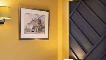 Quadro com uma cena de rua mostrando edifícios e um moinho de vento numa parede amarela.