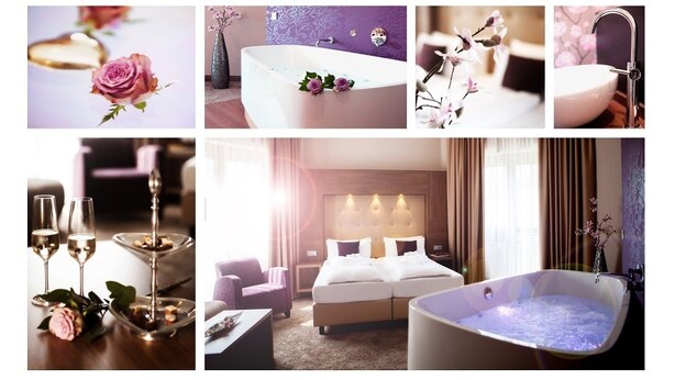 Quarto de hotel com banheira, cama, área de estar e espaço de jantar com copos.