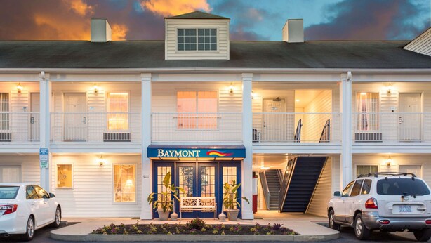 Um hotel de dois andares com uma placa 'Baymont', uma entrada coberta e uma escadaria que leva ao andar superior.