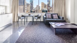 Uma sala de estar moderna com vista para a cidade, uma área de refeições e uma cozinha.