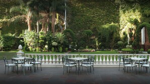 Um pátio com área de estar externa e um jardim bem cuidado.