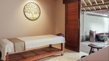 Quarto com um banco de madeira, luminária na parede e vista para uma área de spa com hidromassagem.