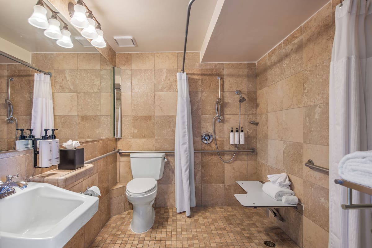 Uma casa de banho moderna com banheira, sanita, lavatório e chuveiro.