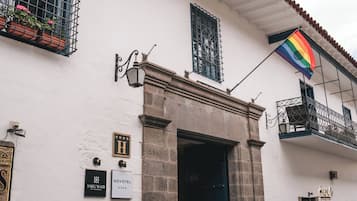 Um edifício com porta preta, uma placa com a inscrição 'NOVOTEL' e uma bandeira.