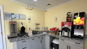 Uma cozinha compacta com micro-ondas, torradeira e máquinas de café.