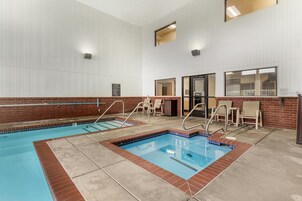 Piscina interior com duas pistas, rodeada por um muro de tijolos e um deck revestido com azulejos.