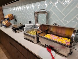 Disposição de buffet com diversos alimentos e utensílios.