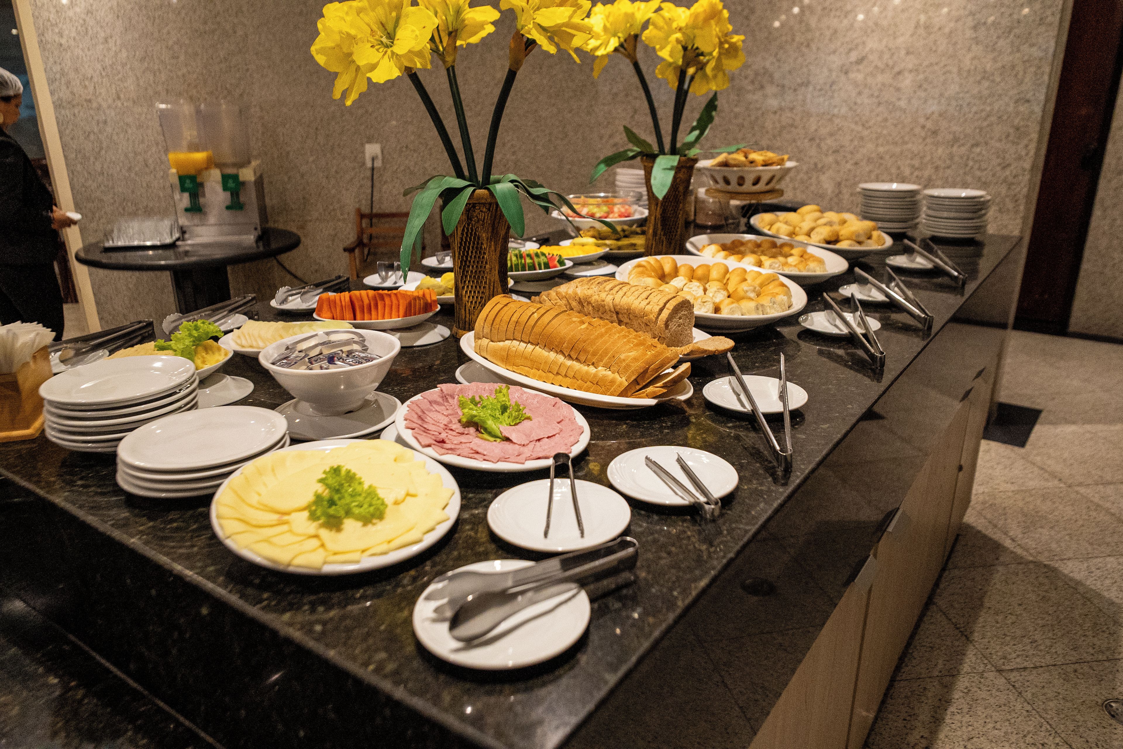 Uma mesa de buffet com diversos alimentos e utensílios.