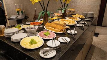 Uma mesa de buffet com diversos alimentos e utensílios.