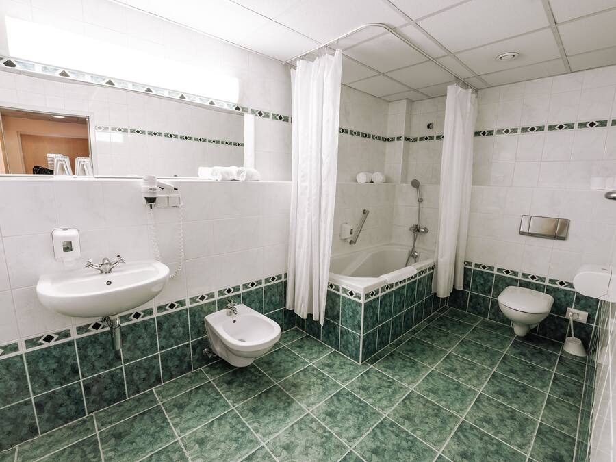 Uma casa de banho com lavatório, bidé, sanita e zona de duche.