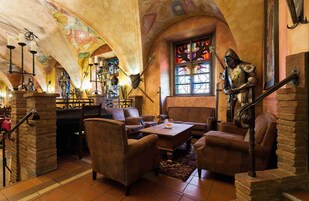 Um interior acolhedor com sofás de couro, uma mesa de centro de madeira e uma janela de vitrais.