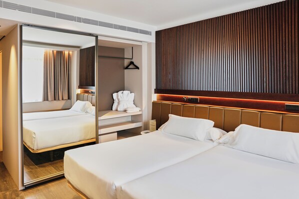 Quarto de hotel moderno com uma cama grande, um closet espaçoso e parede de painel de madeira.