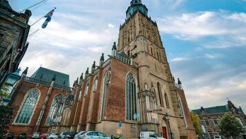 Uma igreja histórica com uma torre alta e janelas em arco grandes.