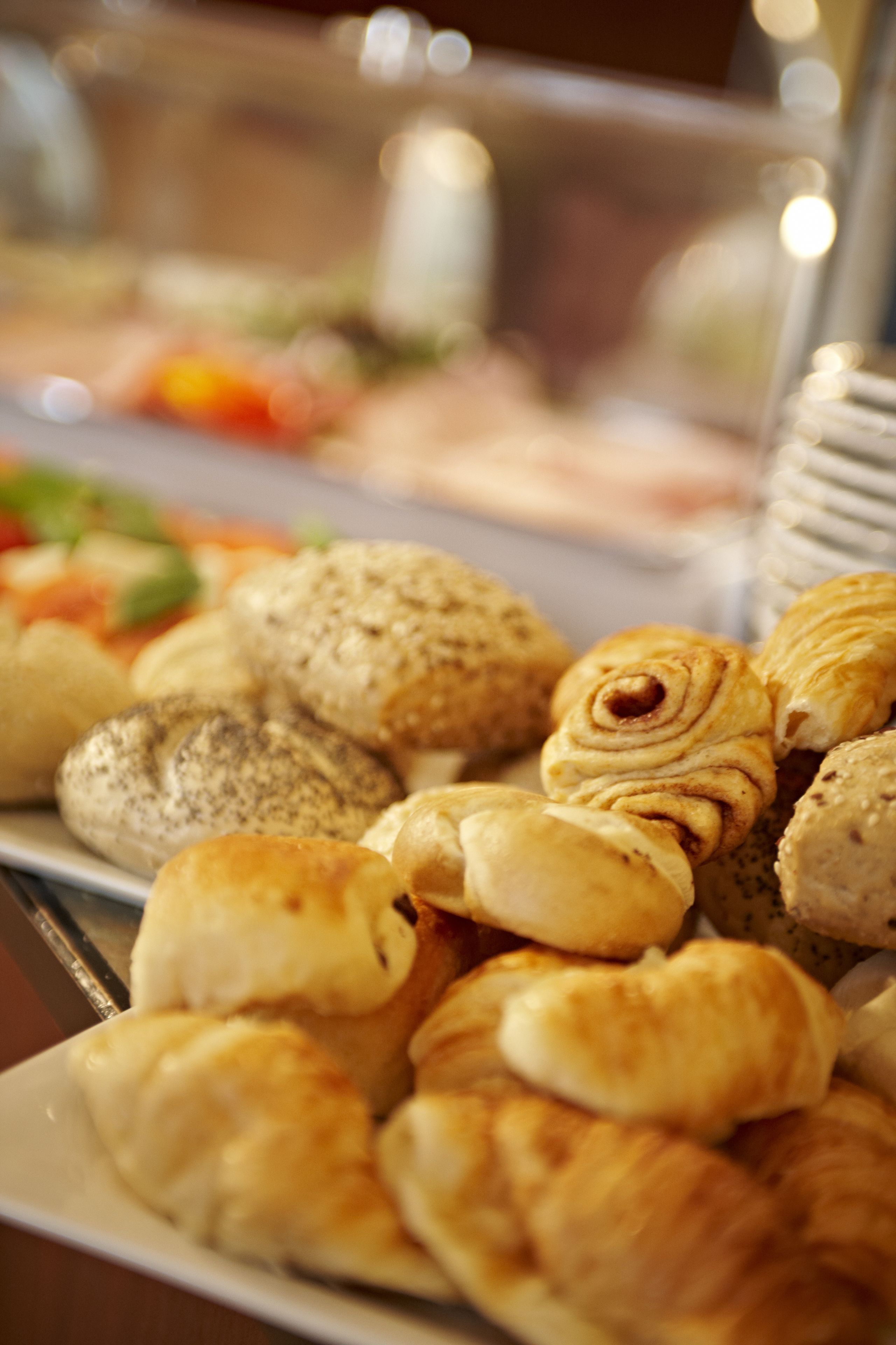 Buffet com diversos produtos de panificação, incluindo doces e pão.