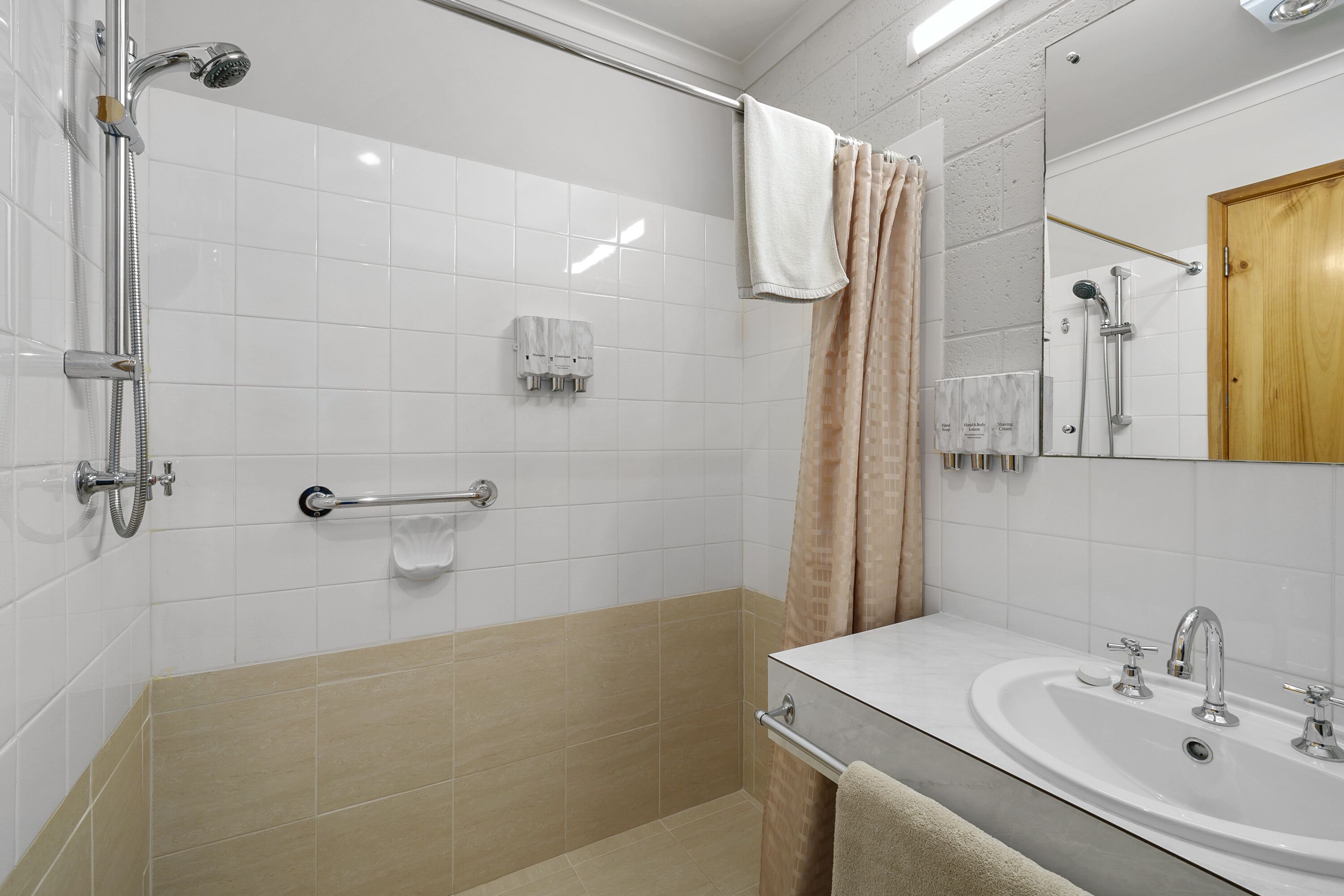 Uma casa de banho moderna com cabine de duche, lavatório duplo e porta-toalhas.