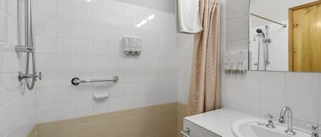 Uma casa de banho moderna com cabine de duche, lavatório duplo e porta-toalhas.