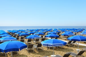 Uma praia privada, espreguiçadeiras, guarda-sóis de praia 
