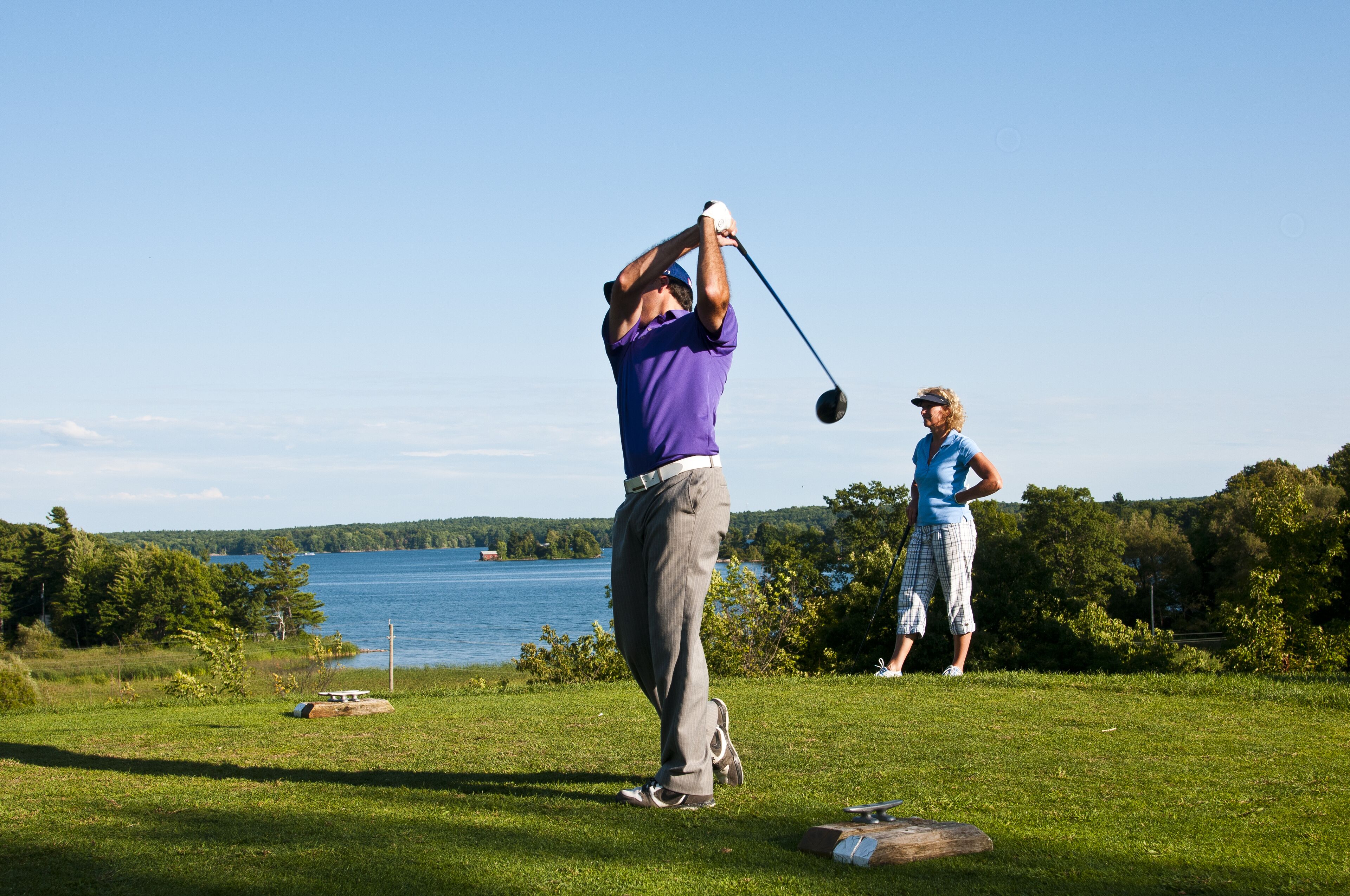 Um campo de golfe com um lago ao fundo.