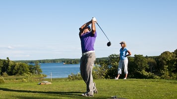 Um campo de golfe com um lago ao fundo.