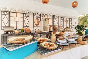 Disposição de buffet com diversos alimentos e elementos decorativos.