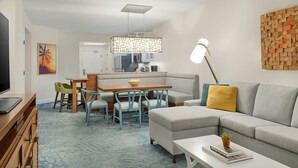 Uma sala de estar moderna com sofá, mesa de centro e área de jantar.