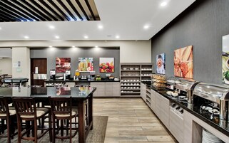 Uma sala de café da manhã moderna com balcão, assentos e serviço de buffet.