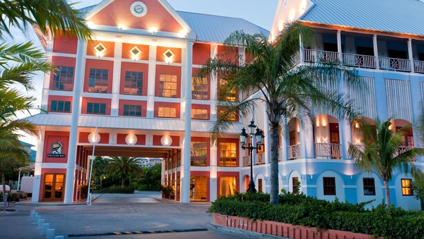 Um hotel com vários andares, entrada destacada, varandas e fachada bem iluminada.